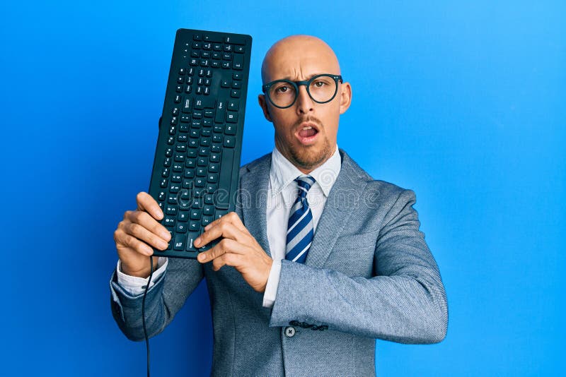 Bald Man with Beard Holding Keyboard in Shock Face, Looking Skeptical ...