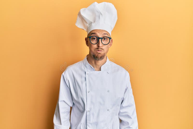 Bald Man With Beard Wearing Professional Cook Uniform Puffing Cheeks