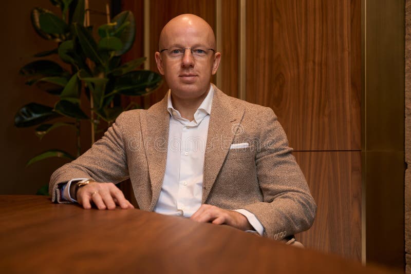 Bald Man in a Beige Jacket Sits at Wooden Table Stock Photo - Image of ...