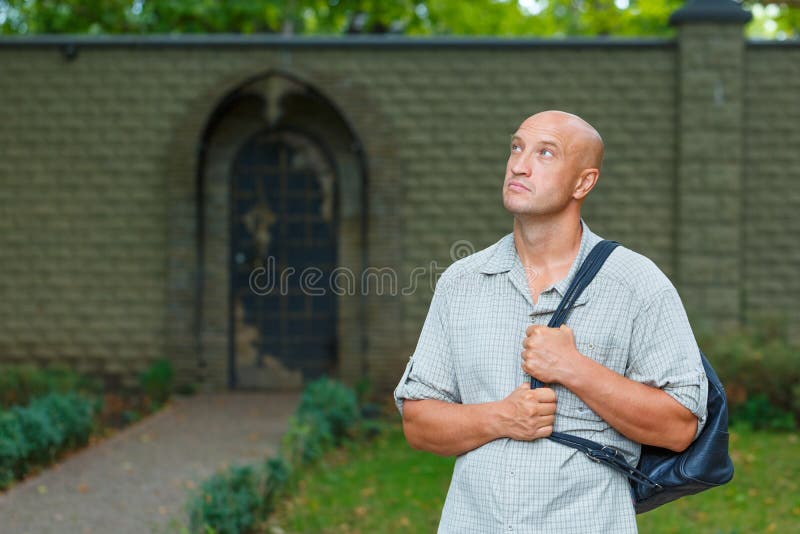 Bald Man Stands on Street with Backpack on His Back and Looks Away ...