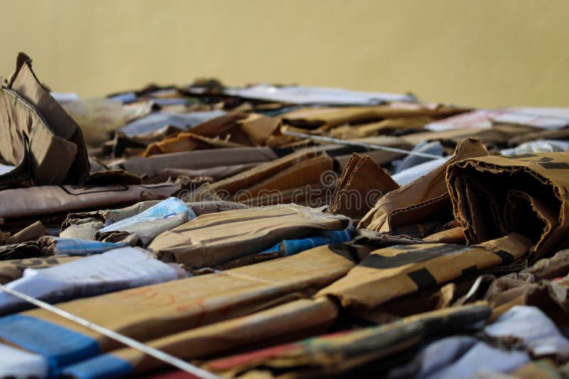 A Bale of Pressed Corrugated Cardboard Boxes Ready for Recycling Against a Wall Abstract ...