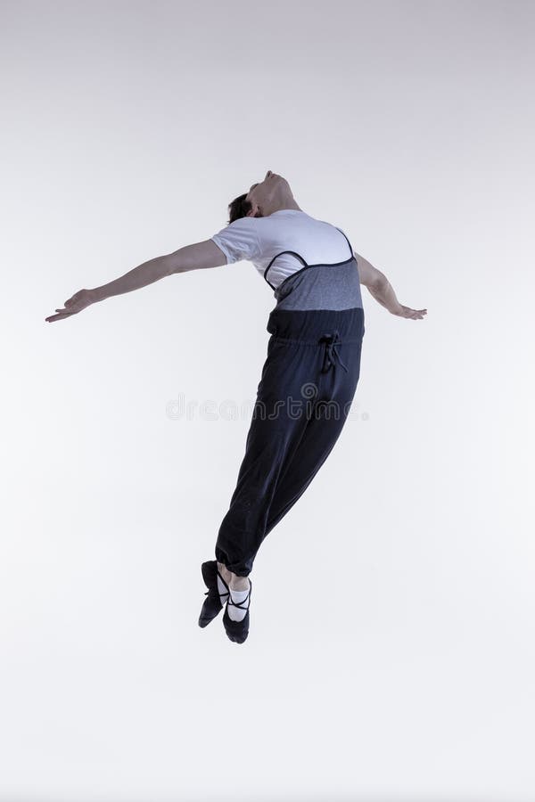 Ballet Dancer Performing in Flight with Hands Outspread in Studio Over ...