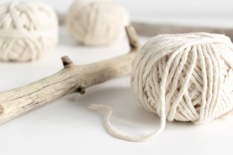 Balls of White Yarn and Rustic Sticks on a White Table. Threads of Wool ...