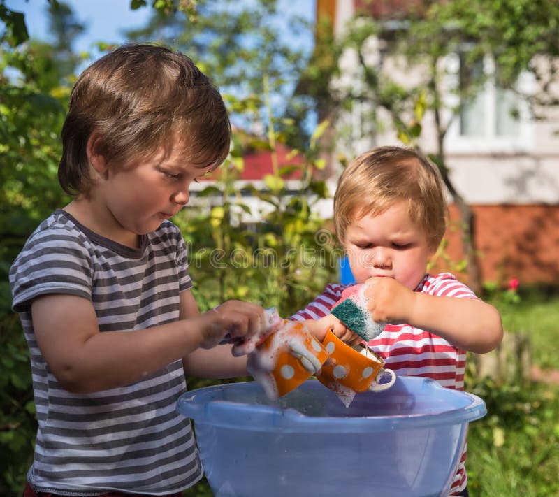 Bambini Che Lavano I Piatti All'aperto Fotografia Stock - Immagine di ...