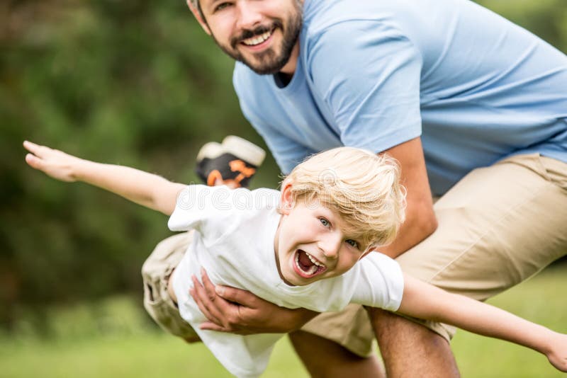 Bambino Che Ride E Che Gioca Con Il Padre Fotografia Stock - Immagine ...