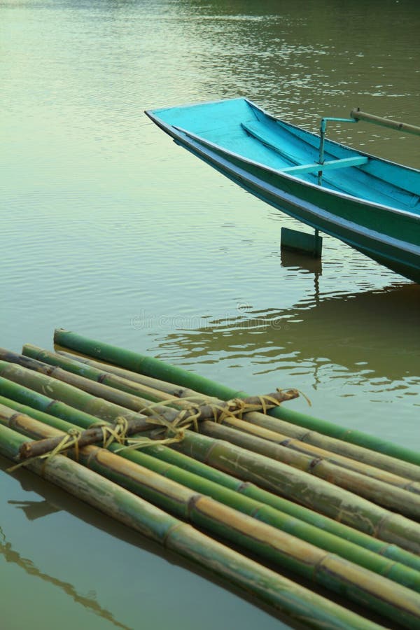 Bamboo Raft and Blue Boat on Water Stock Photo - Image of boat, canoe ...