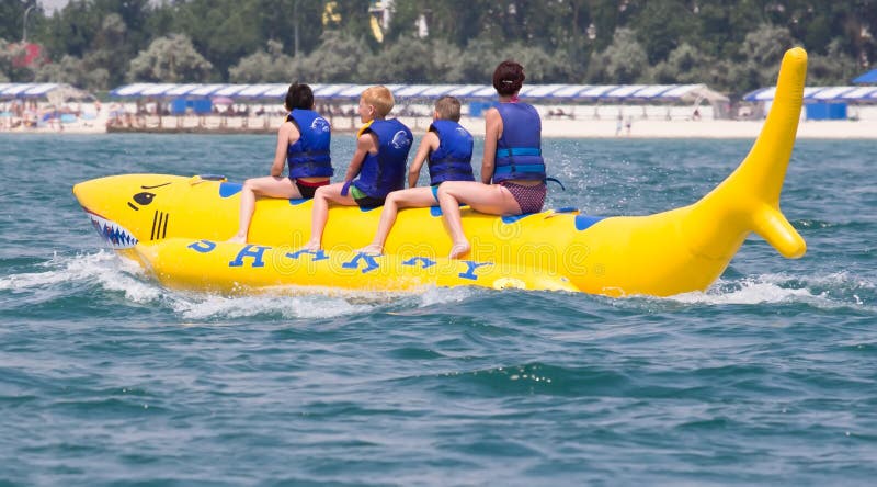 People Ride on Banana Boat. Bright Blue Sea and Blue Sky with Clouds ...