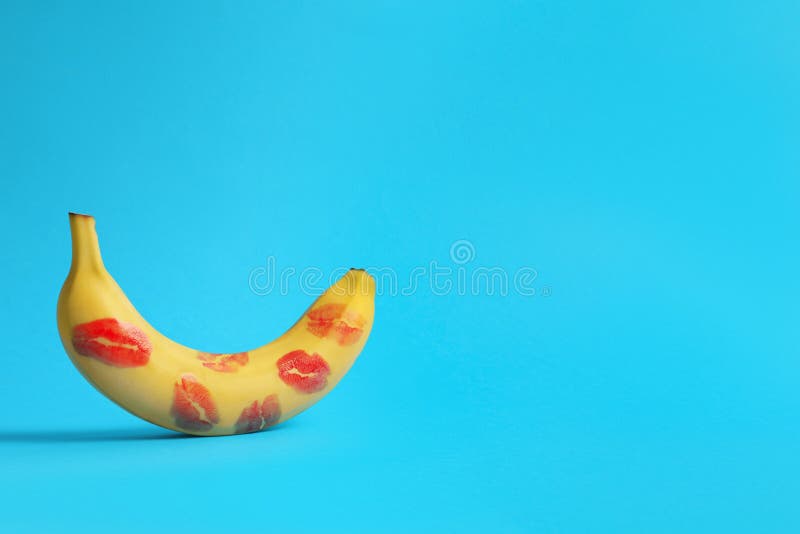 Banana Covered With Red Lipstick Marks On Light Blue Background Space For Text Potency Concept