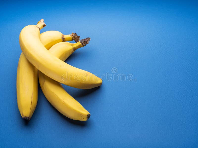 Bananas en el fondo azul imagen de archivo. Imagen de fruta - 239901465