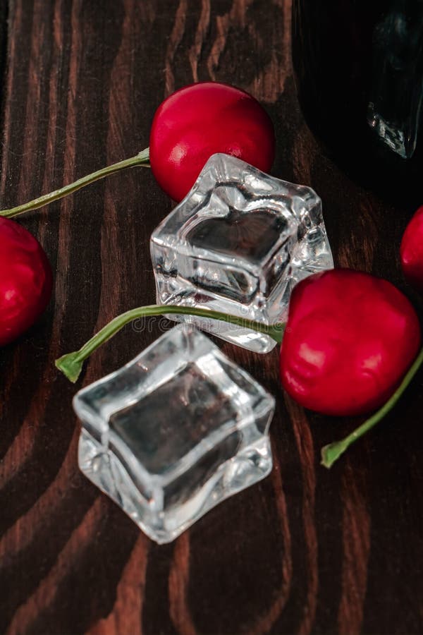 Banch of Red Cherry and Ice Cubes on Black Wet Table. Selective Focus ...