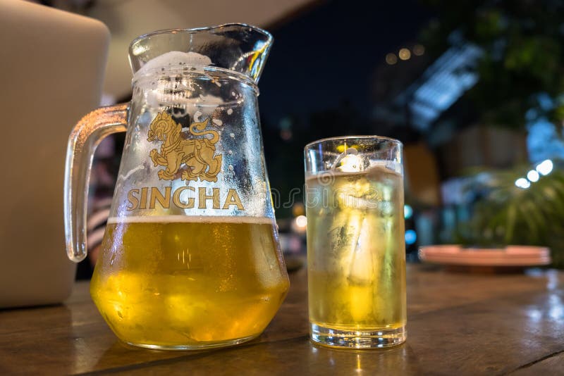 A Pitcher of Singha Beer with a Glass of Beer on the Table Stock Photo ...