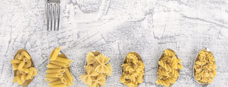 Banner One Fork and Various Pasta on Spoons Over White Stone Background ...