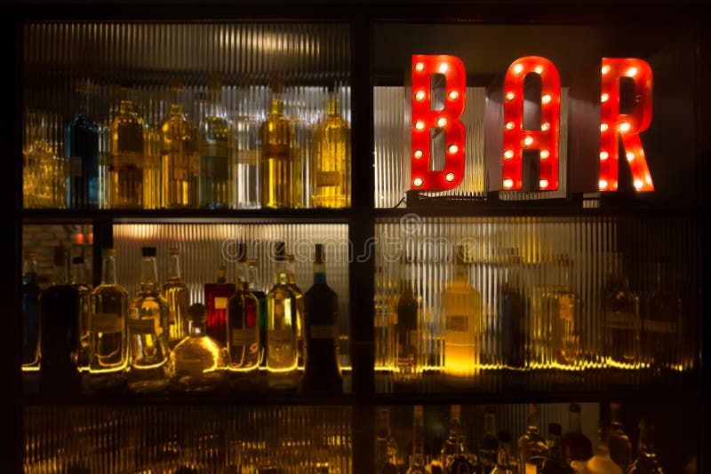 BAR Sign with Lights in the Dark with Many Shapes of Bottles of Alcohol ...