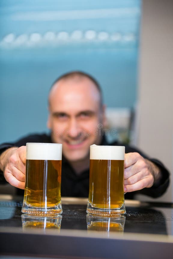 Bar tender offering beer stock image. Image of beverage - 77695361