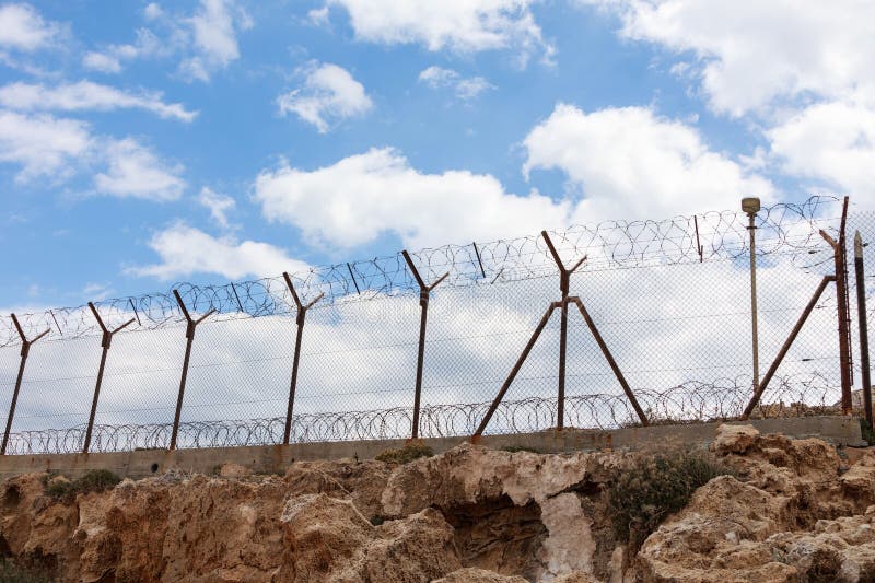 Barbed Wire Fence on a Blue Sky Background. a Large, High Wire Fence ...