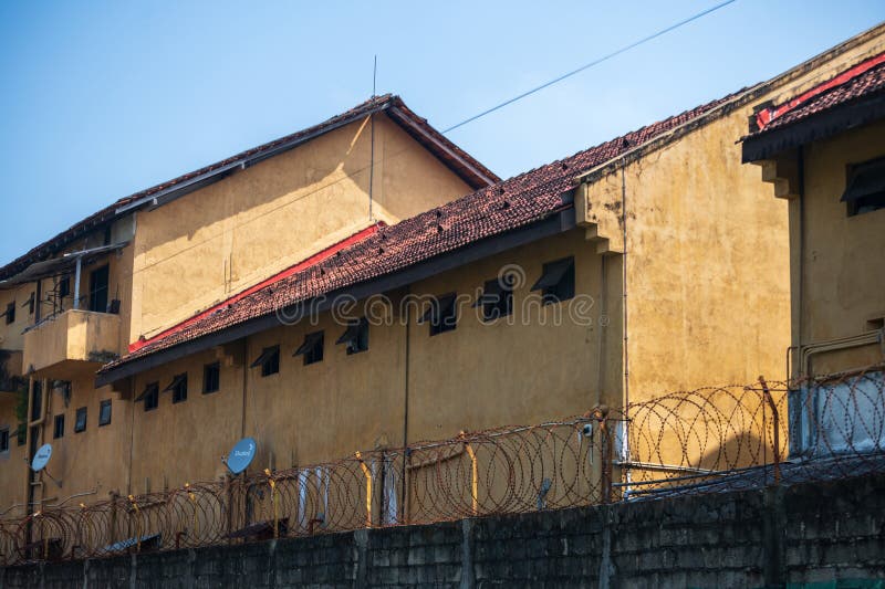 Barbed Wire Fence with Yellow Colored Old Prison Type Buildings Stock ...