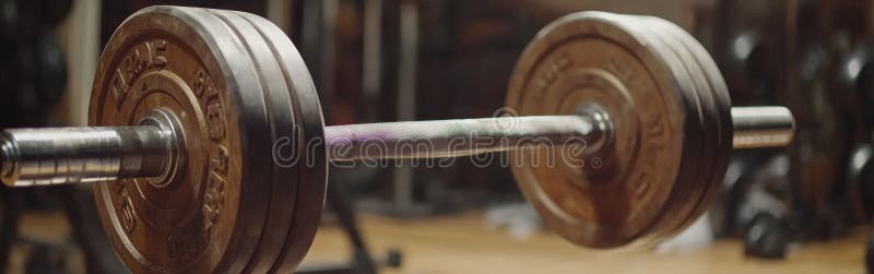 A Barbell Loaded with Heavy Weights Rests on a Gym Floor, Showcasing ...