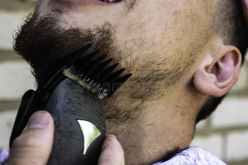 The Barber Cuts His Beard To a Guy with a Shearing Machine Stock Image ...