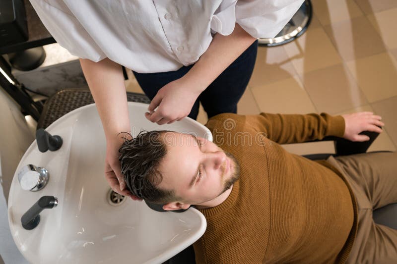 Barber Shampooing Washing a Male Clients Head in the Sink. Stock Image ...