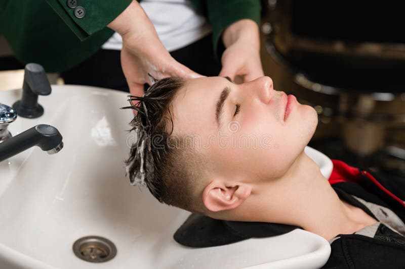 Barber Shampooing Washing a Male Clients Head in the Sink. Stock Image ...