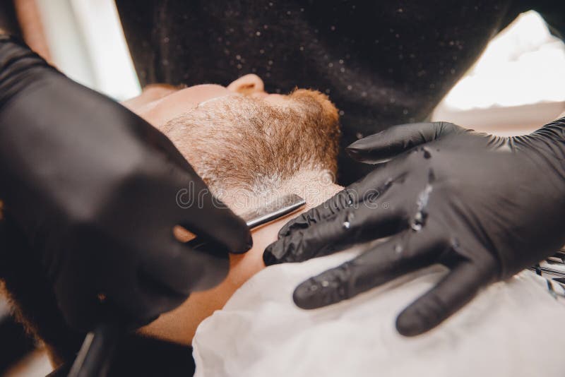 Barber Shaves Beard of Man in Barbershop with Razor Stock Photo - Image ...