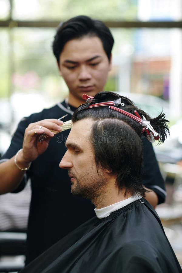 Barber Trimming Long Hair stock photo. Image of brunet - 319864322