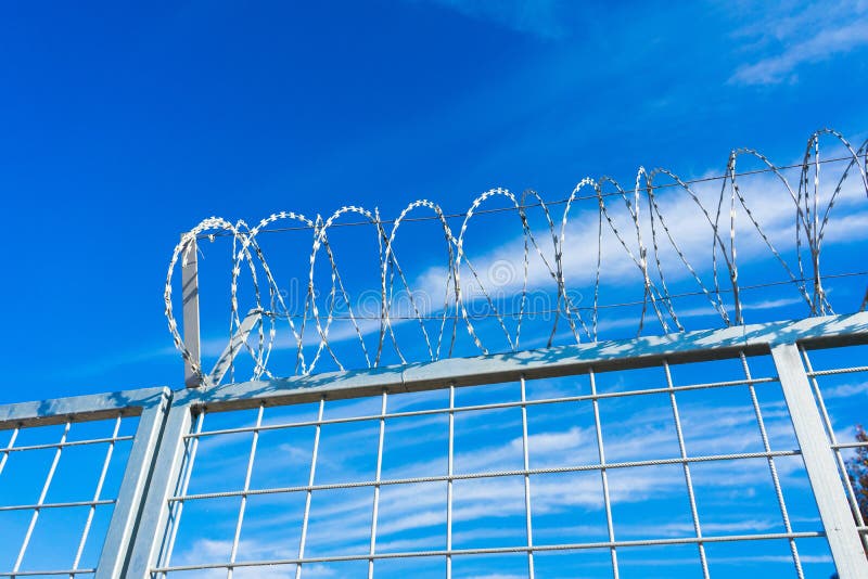Barbered Wire Over a Blue Sky and on Building Ground, Rusty Stock Photo ...