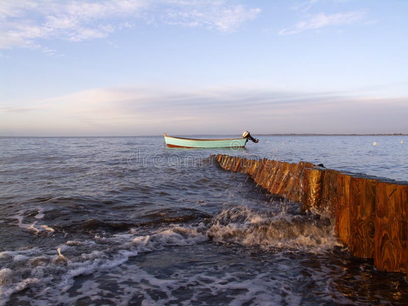 Barco y rompeolas foto de archivo. Imagen de sunset, dorado - 72144