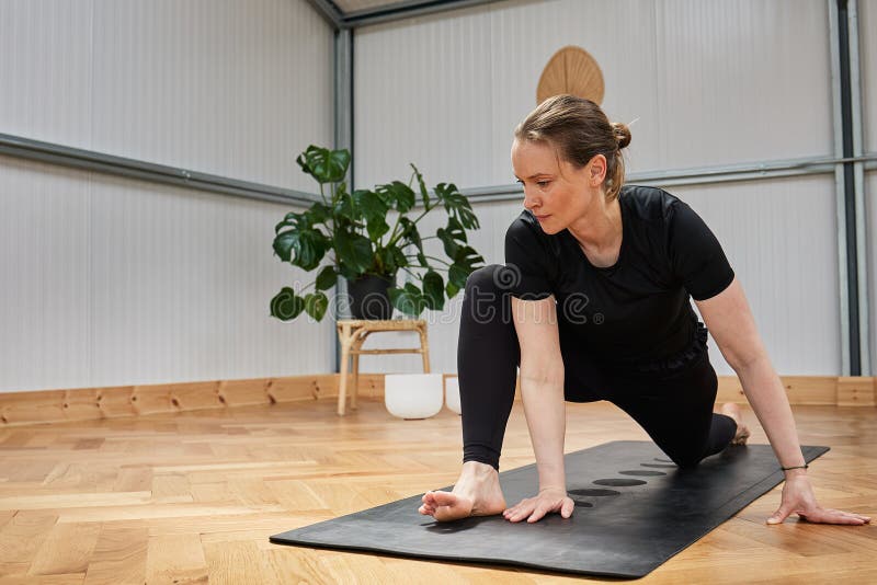 Barefoot Woman Practicing Yoga Stretches on Mat in Indoors Studio Stock ...