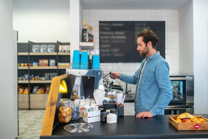 Barista Making Coffee in the Cafe and Looking Contented Stock Photo ...