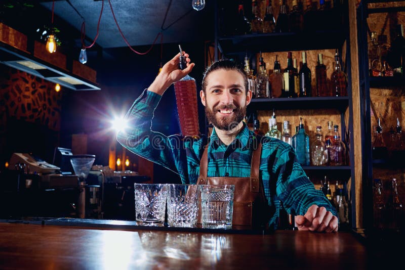 A Barman with Bottle of Alcohol Smiles Laughing at the Bar Stock Photo ...