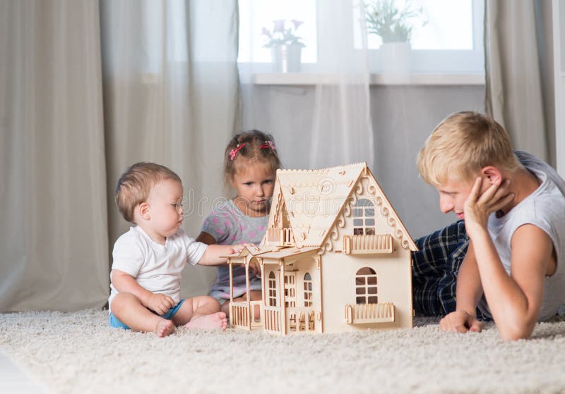 Barnlek med ett dockhus fotografering för bildbyråer. Bild av kaukasisk ...