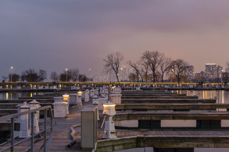 Barren Trees and a Purplish Sky Behind Empty Boat Docks on Chilly Night ...