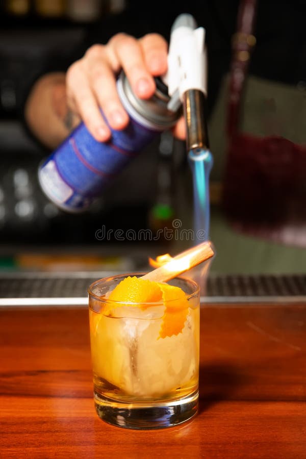 The Bartender Burns a Cinnamon Stick with a Gas Burner in the Bar ...