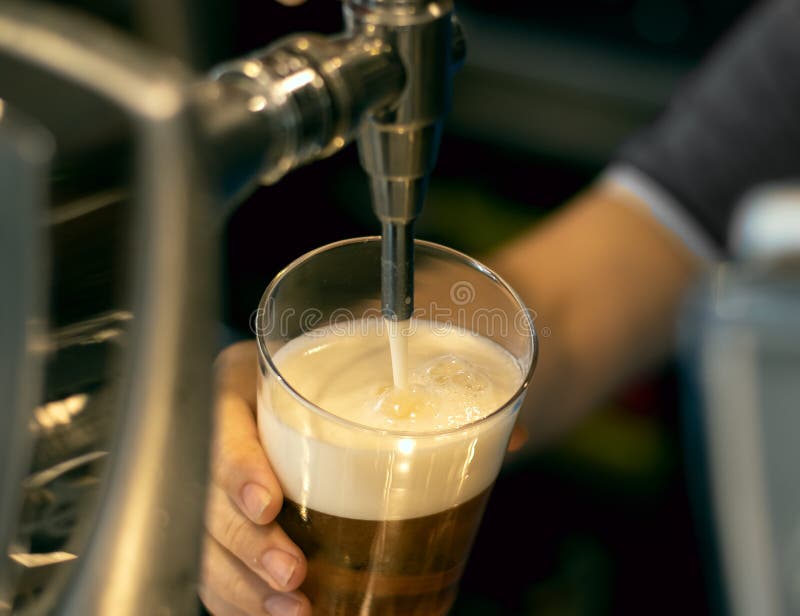 Bartender Hand at Beer Tap Pouring a Draught Beer in Glass Serving in a ...