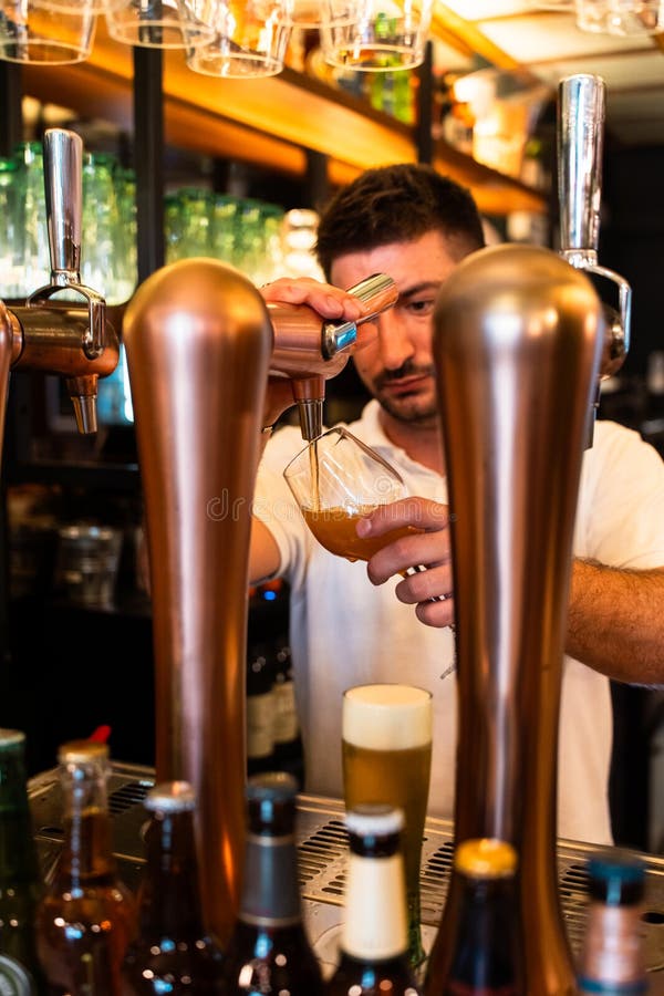 Bartender Pouring Beer with the Assortment at the Bar. Vertical Stock ...