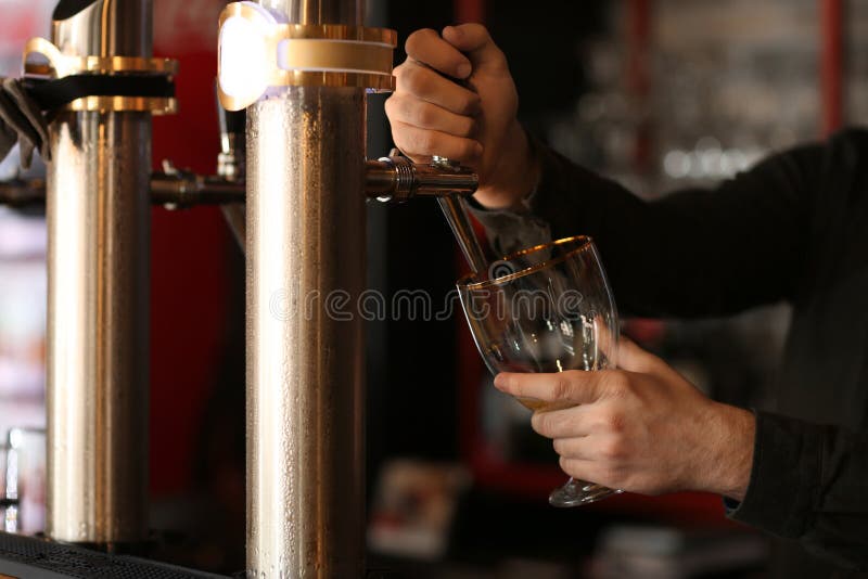 Bartender Pouring Beer into Glass in Bar Stock Photo - Image of indoors ...