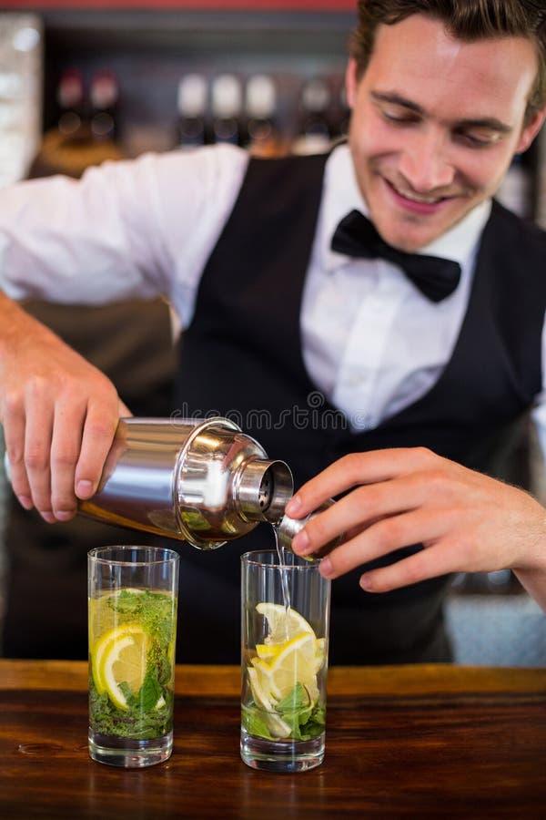 Bartender Pouring a Drink from a Shaker To a Glass on Bar Counter Stock ...