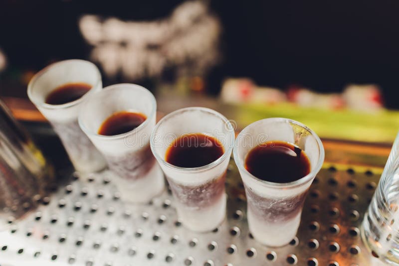 Bartender Pouring Strong Alcoholic Drink into Small Glasses on Bar ...