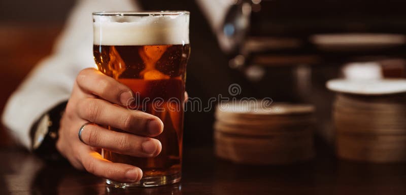 Bartender S Hand with a Glass of Light Draft Beer with Foam in Bar ...