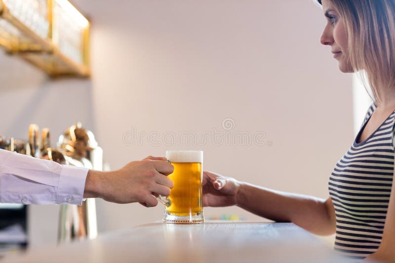 Bartender Serving Beer To Female Customer Stock Photo - Image of female ...