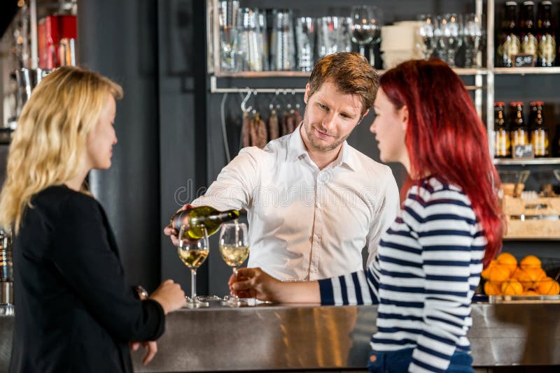 Bartender Serving Wine To Customers in Bar Stock Image - Image of ...