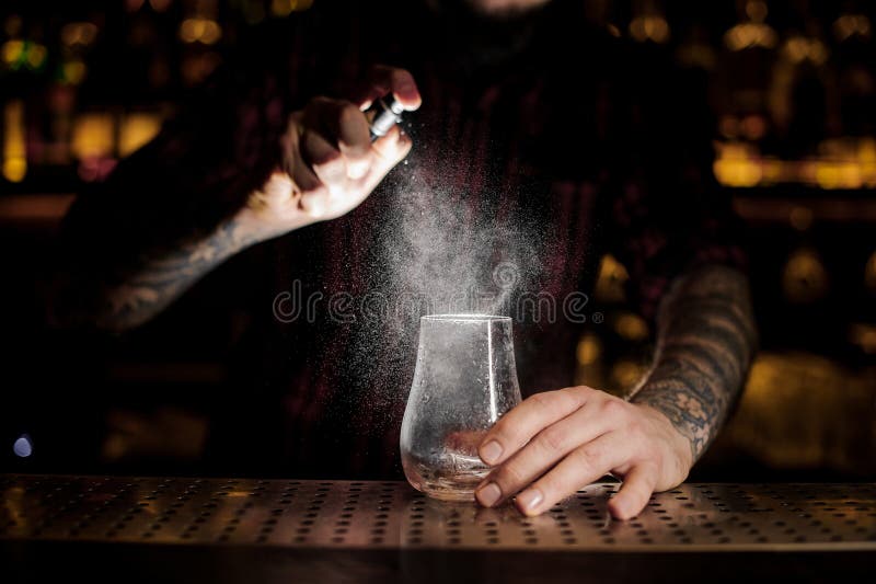 Bartender Spraying on the Empty Cocktail Glass in the Bar Stock Photo ...