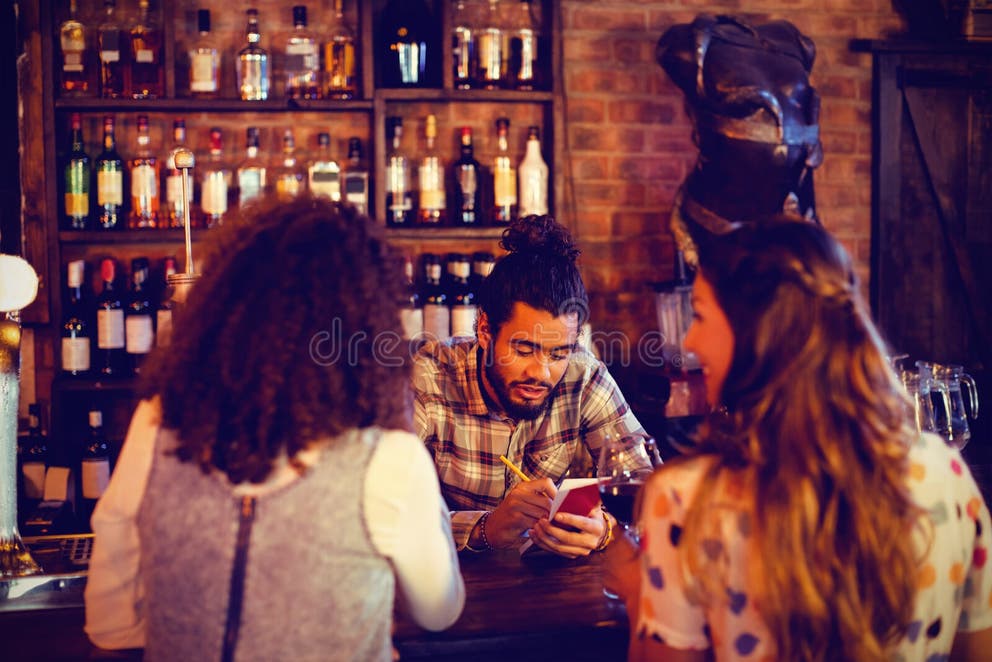 Bartender Taking an Order on Notepad at Counter Stock Photo - Image of ...