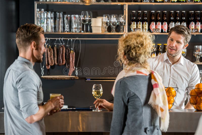 Bartender Talking with Customers at Bar Counter Stock Image - Image of ...