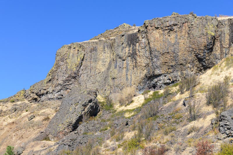 Basalt Cliff Face Rises Above a Dry Slope in Central Washington Stock ...