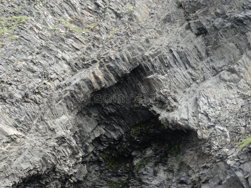 Basalt sea cliff with cave stock image. Image of formation - 77634475