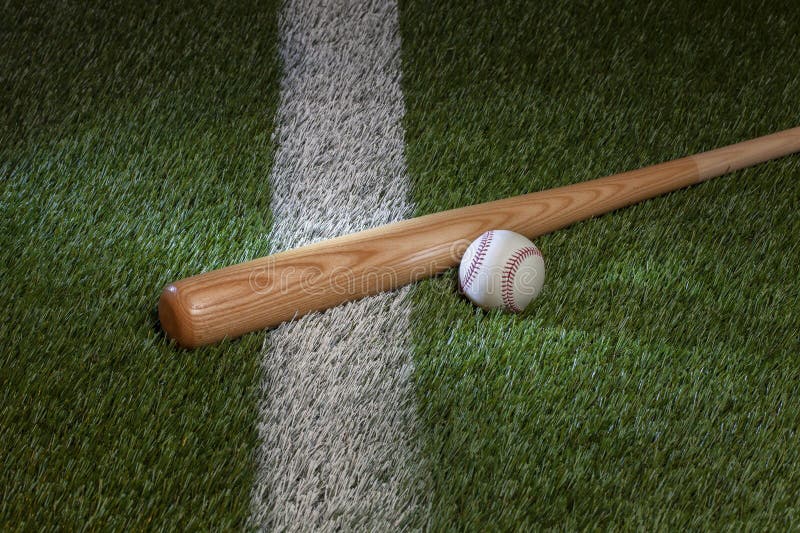 Baseball and Bat on Grass Field with White Stripe at Night Stock Photo ...