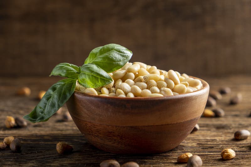 Basil and Pine Nuts in Wooden Bowl on Wooden Background Stock Photo ...