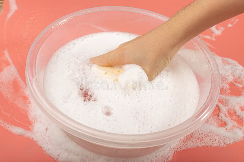 A Basin with Soapy Water, Hand Holds Soapy Sponge with Foam on Pink ...